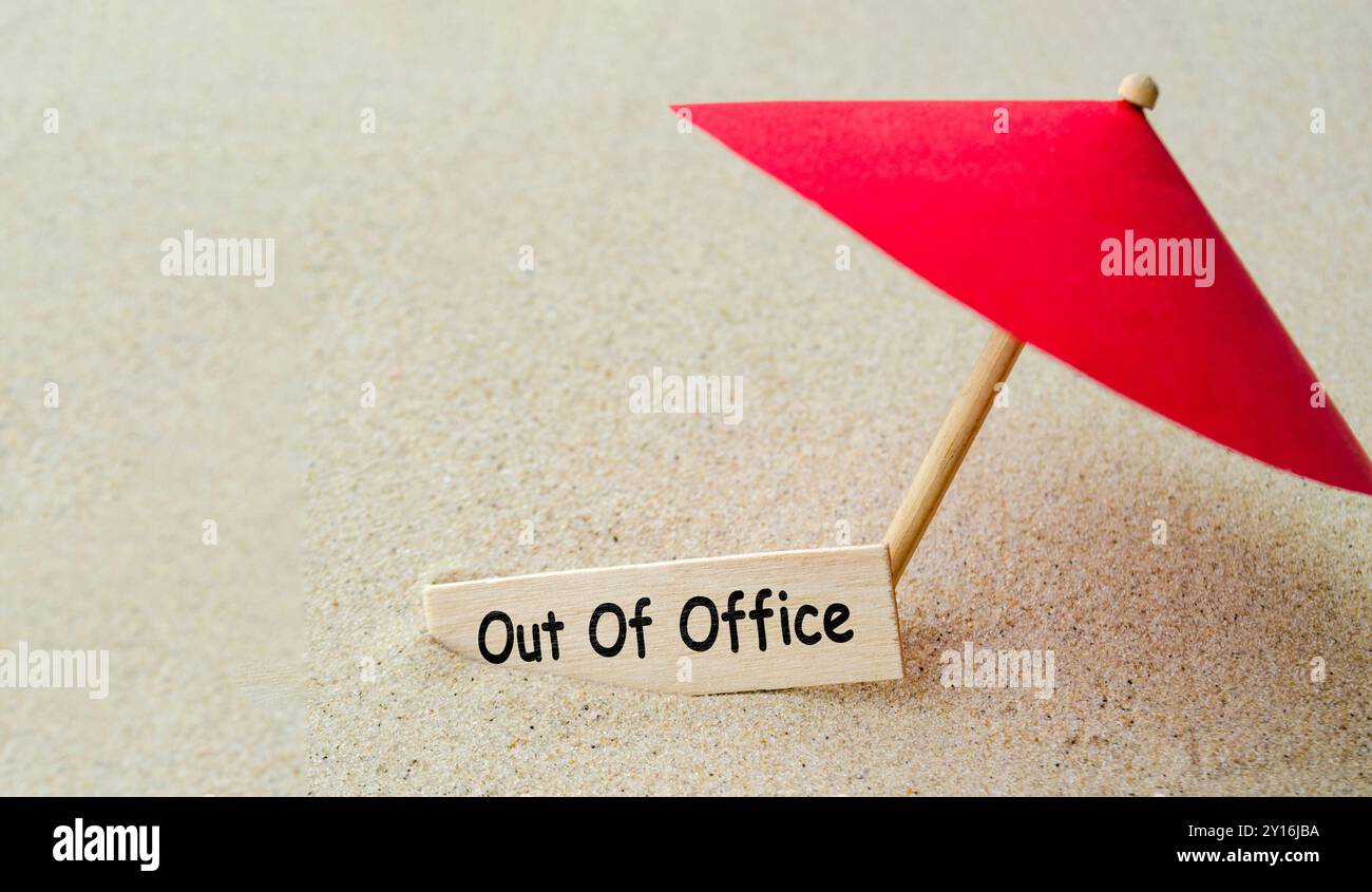 Out of office text on wooden banner with toy umbrella representing off ...