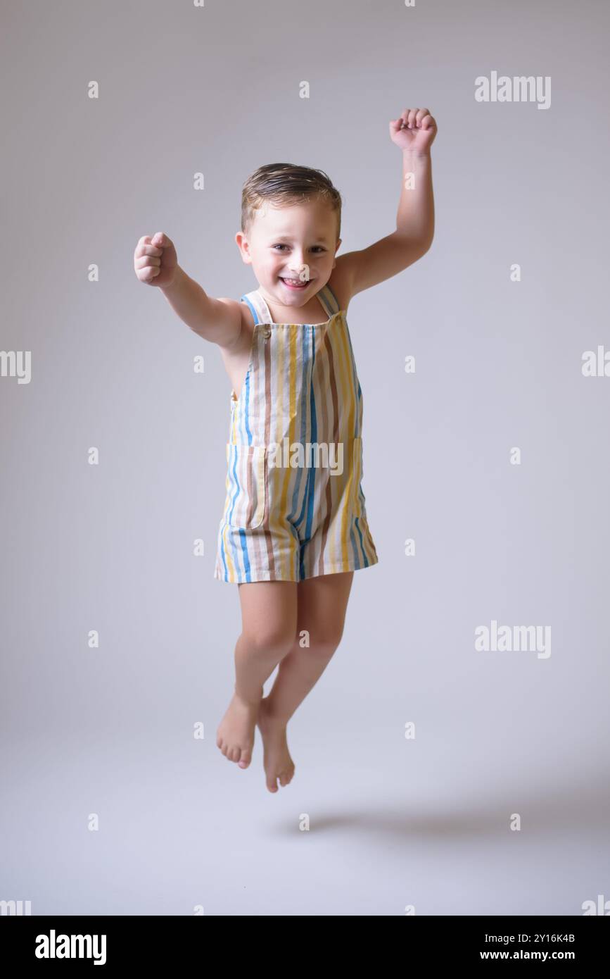 Happy little boy jumping on white background Stock Photo - Alamy