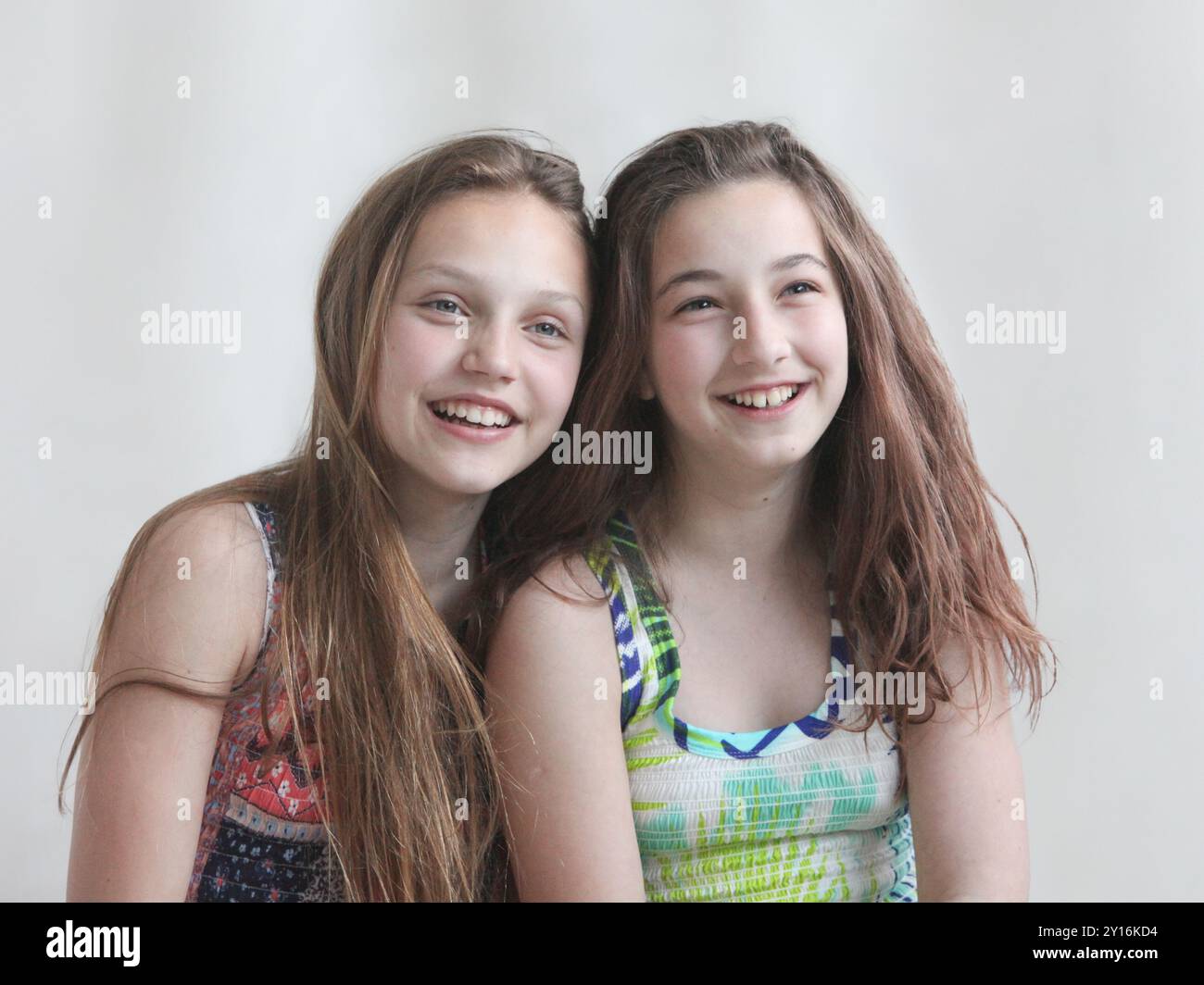 portrait of two happy little girls laughing and goofing around on the ...