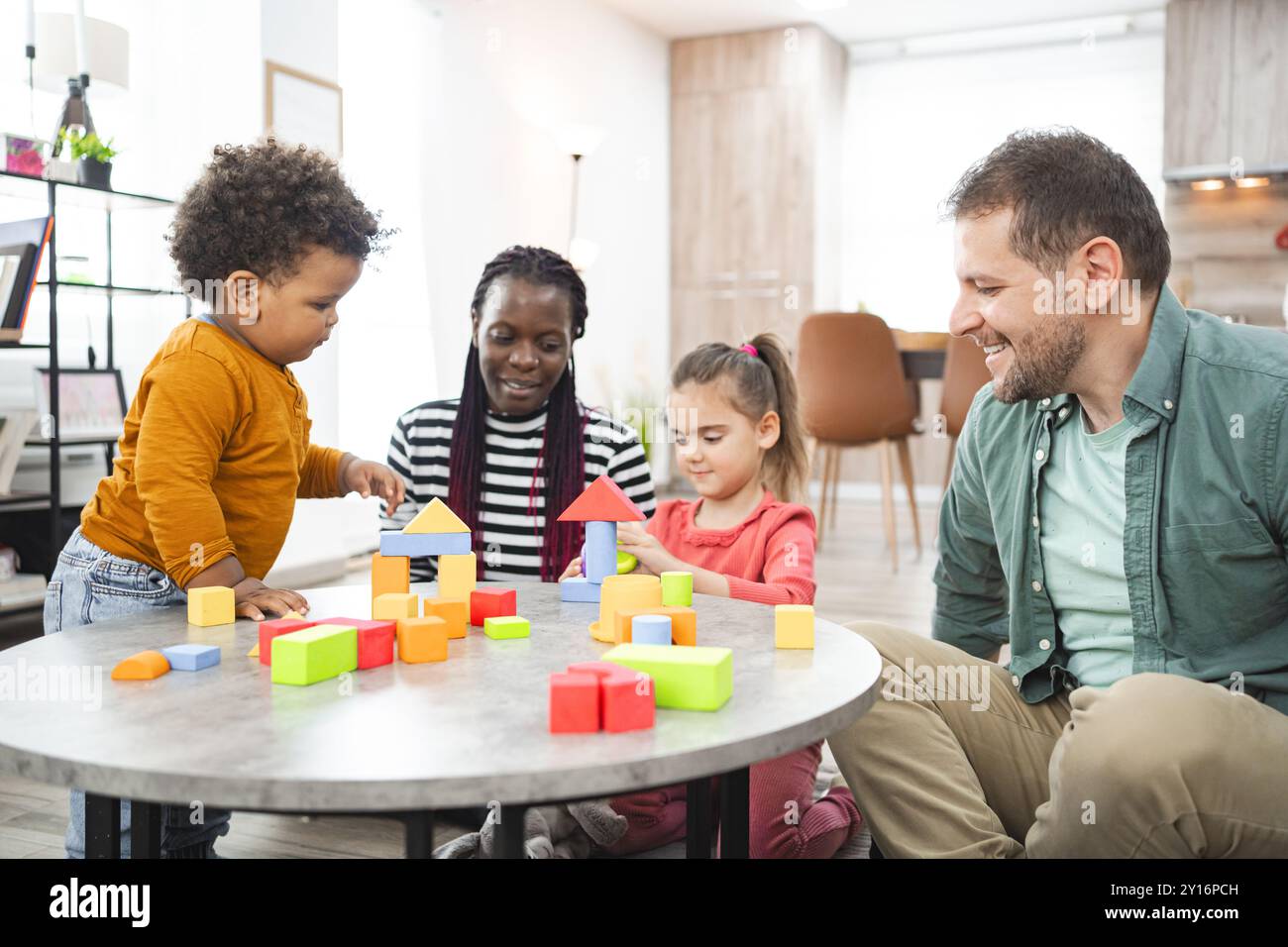 Multiracial family playing with colorful building blocks at home Stock ...