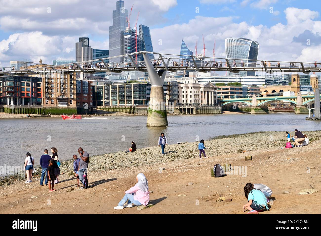 People on the sandy beach that is exposed when the tide is out on the ...