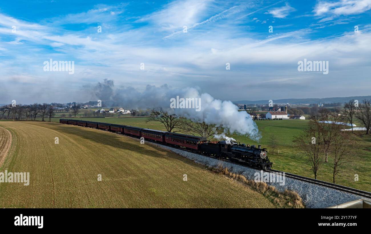 A vintage steam locomotive chugs along scenic railway tracks, billowing ...