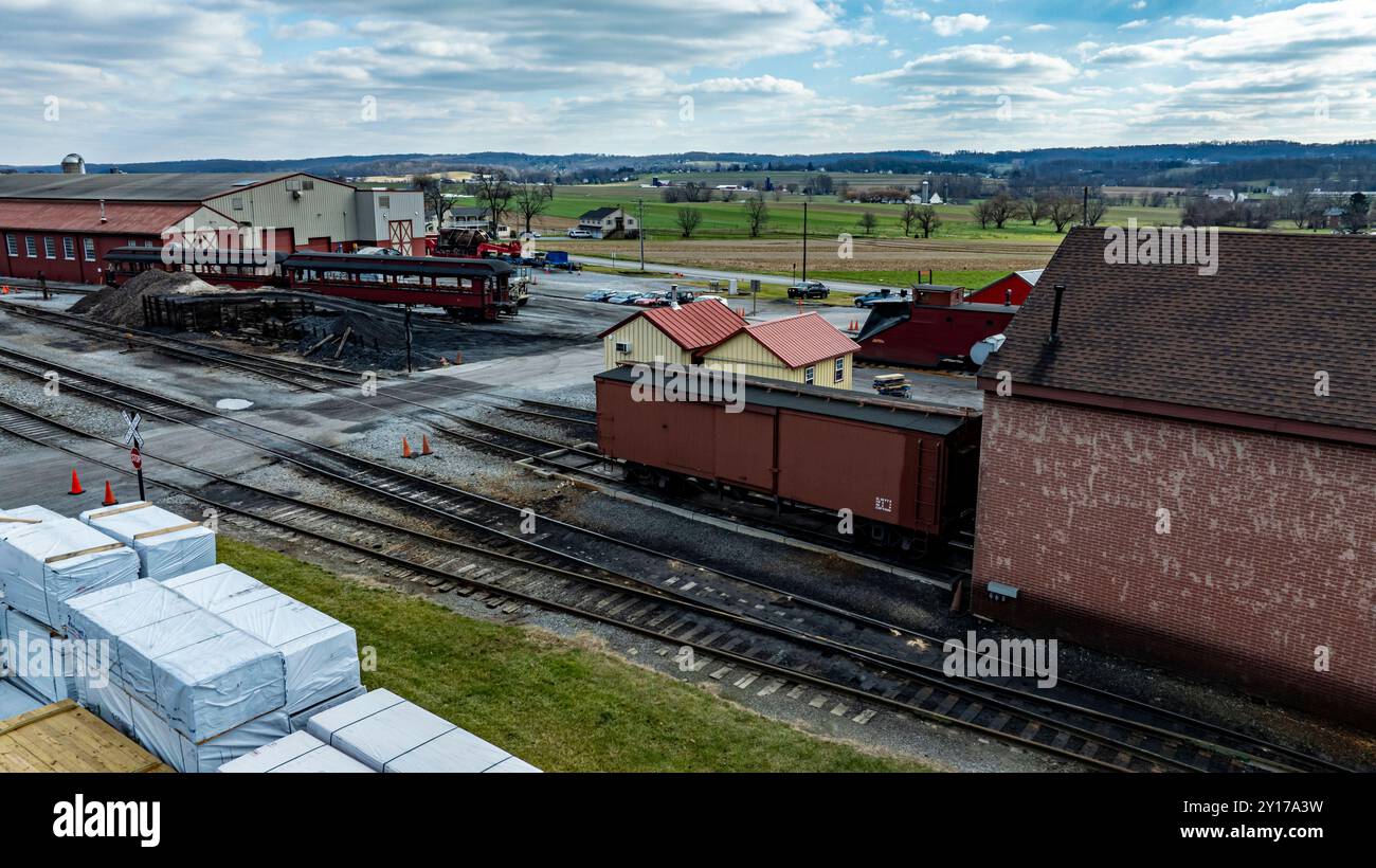 The view captures a train yard featuring several cargo cars parked near ...