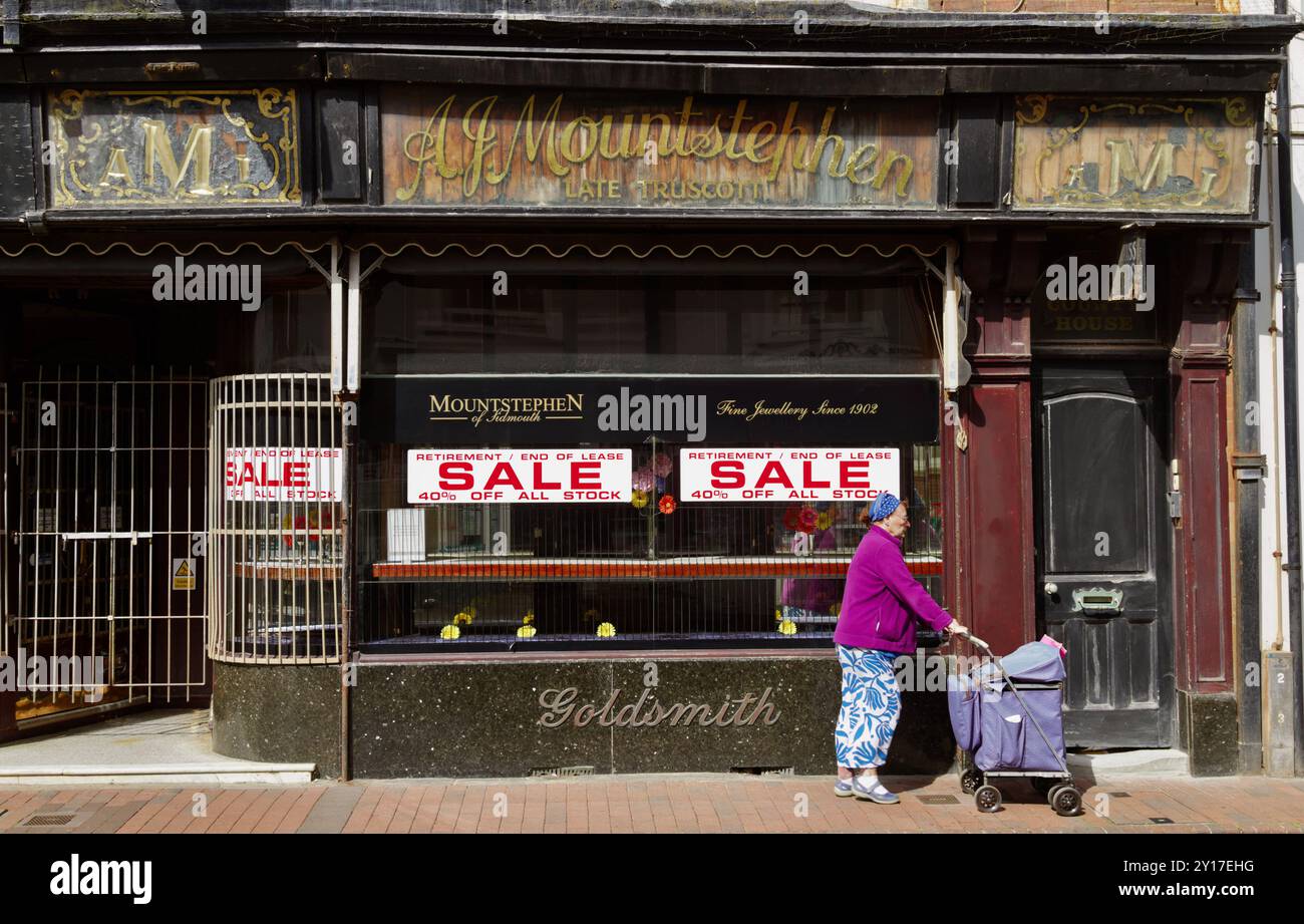 Woman With Shopping Trolley Walking Past The Closed Down Jewellers And ...