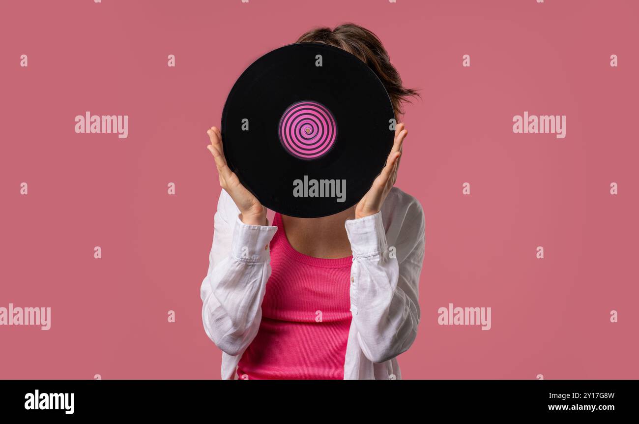 Positive short haired woman with vinyl record disc on pink. Hobby ...