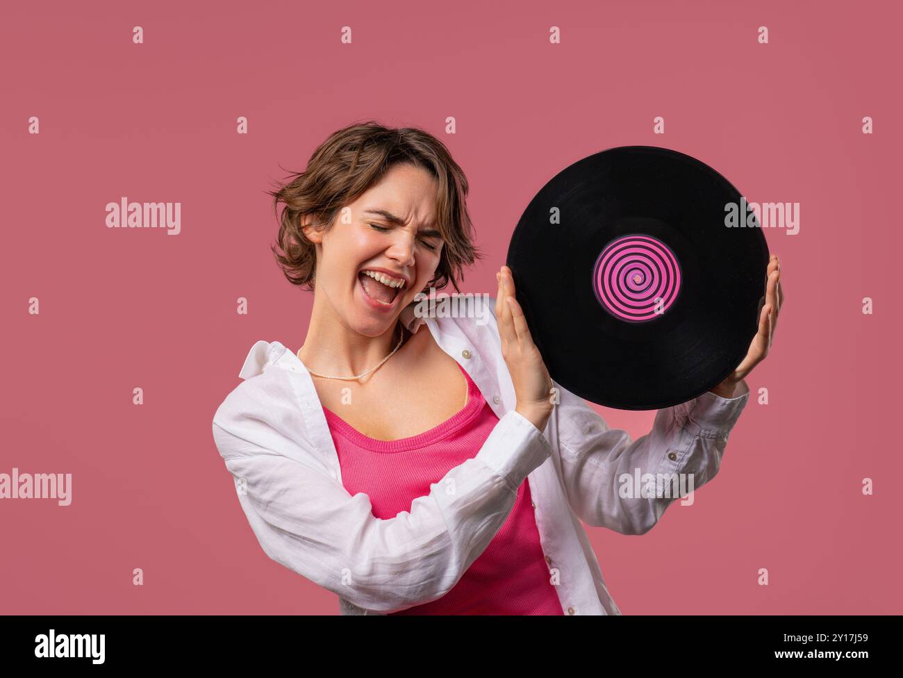 Positive short haired woman with vinyl record disc on pink. Hobby ...