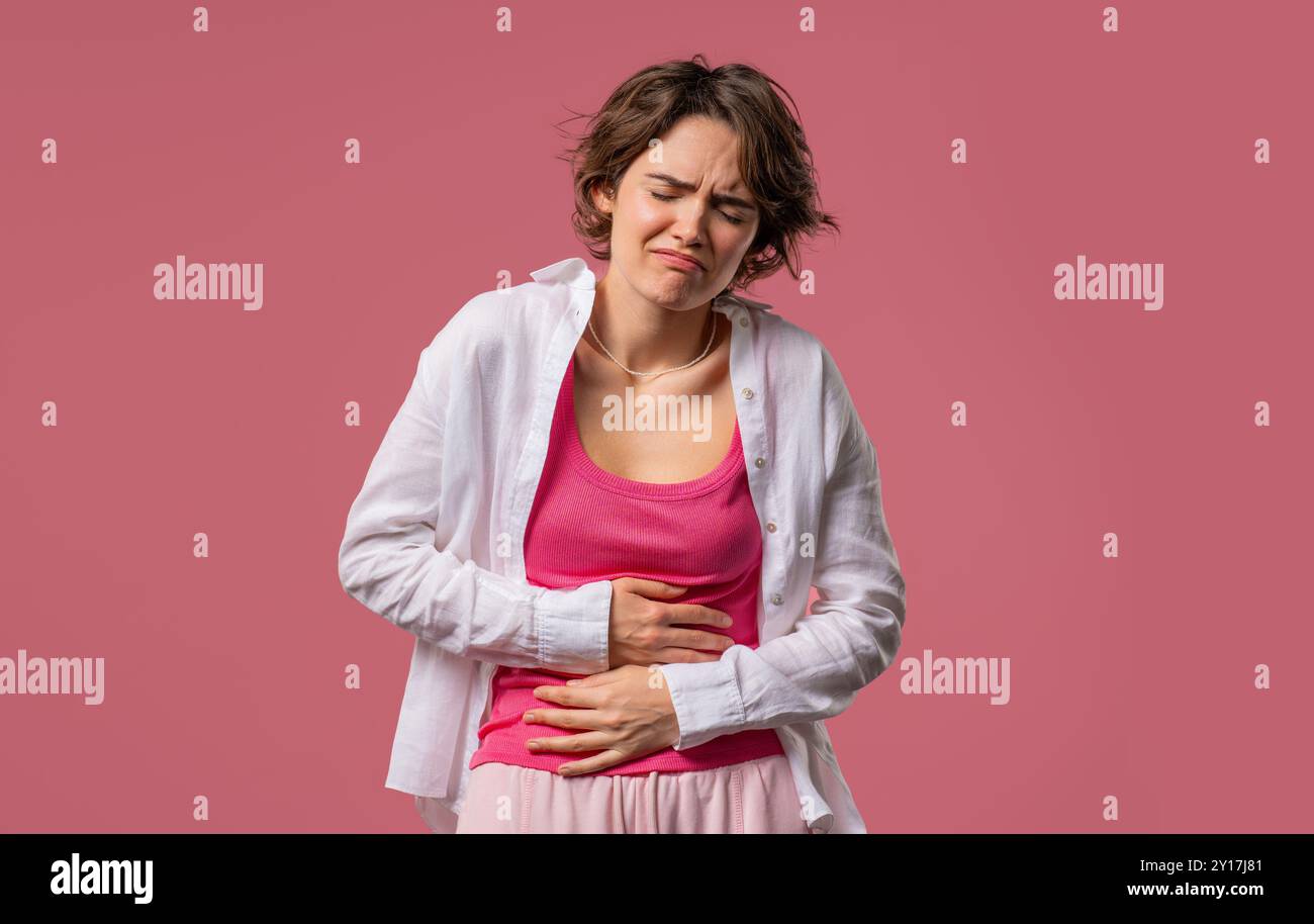 Young woman squeezing belly with hands. abdominal pain, suffering ...