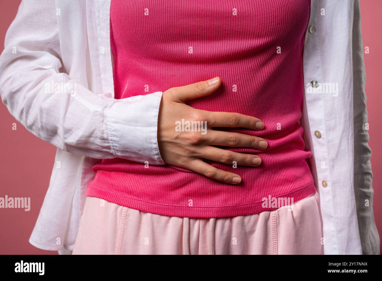 Young woman squeezing belly with hands. abdominal pain, suffering ...