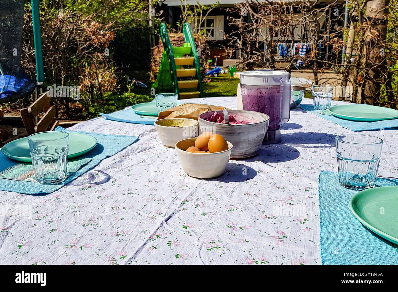 Lunch outdoors on garden terrace, table with variety of foods ...