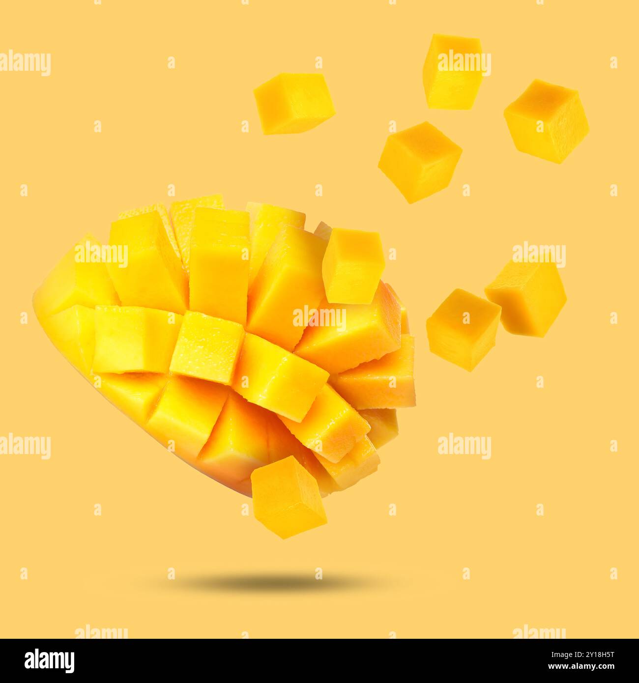 Sweet fresh mango cut in cubes falling on golden background Stock Photo ...