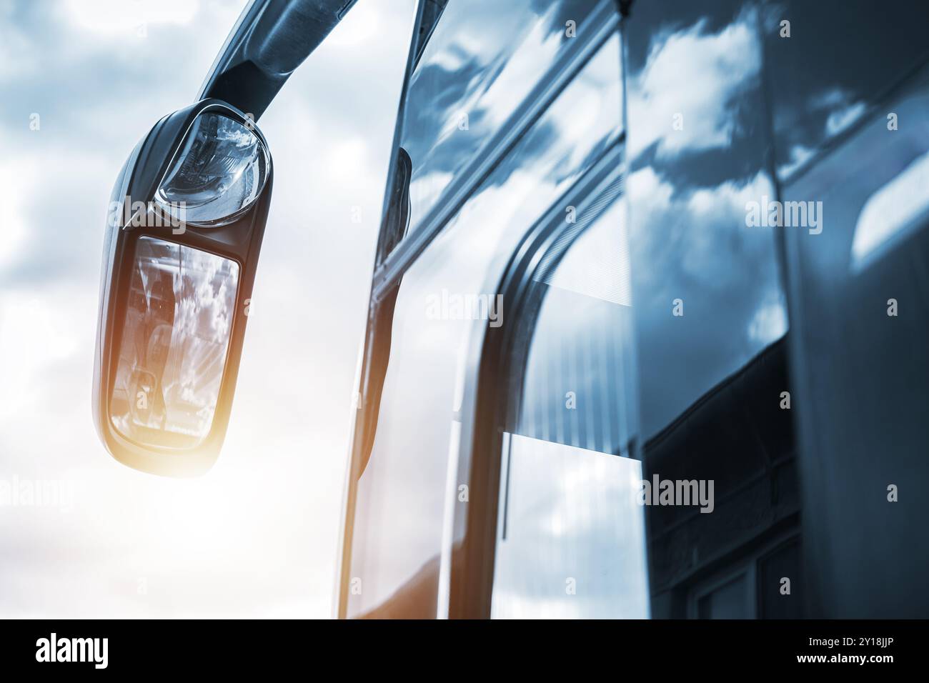 A modern bus mirror glimmers in the sunlight, showcasing a clear ...