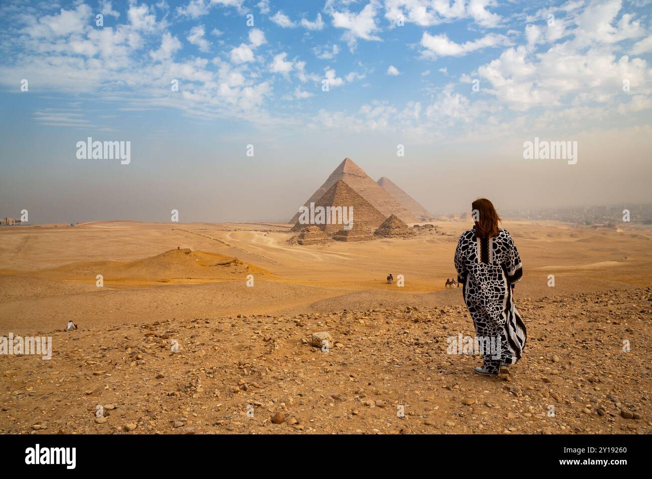 Back view of a woman in a long traditional Muslim dress looking at the ...