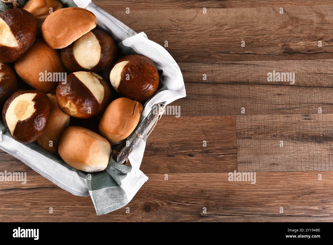 High angle shot of assorted dinner rolls in basket. On a rustic wood ...