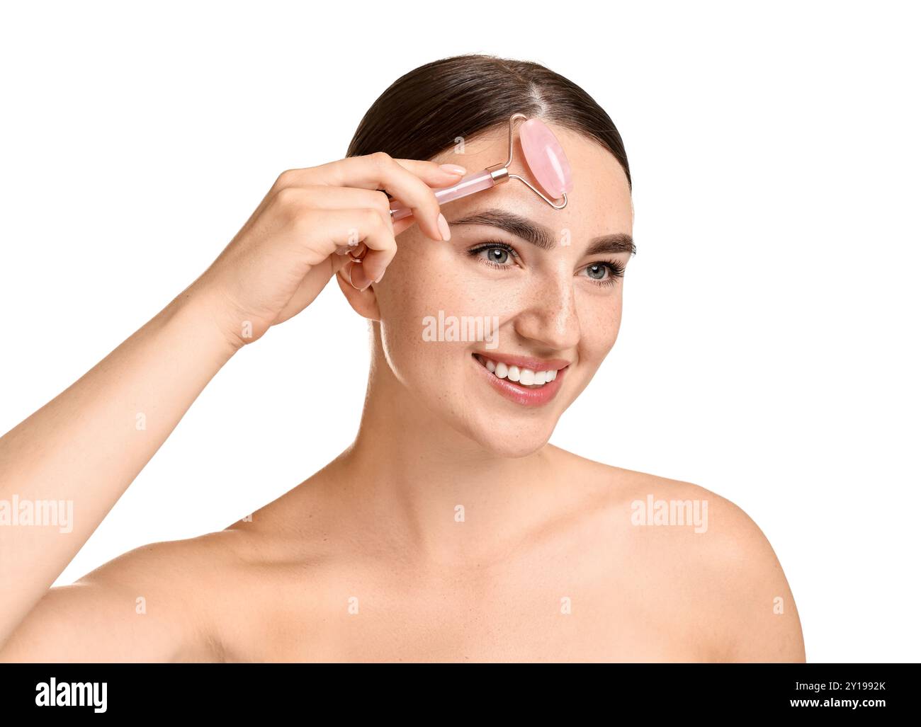 Beautiful young woman doing facial massage with roller on white background Stock Photo - Alamy