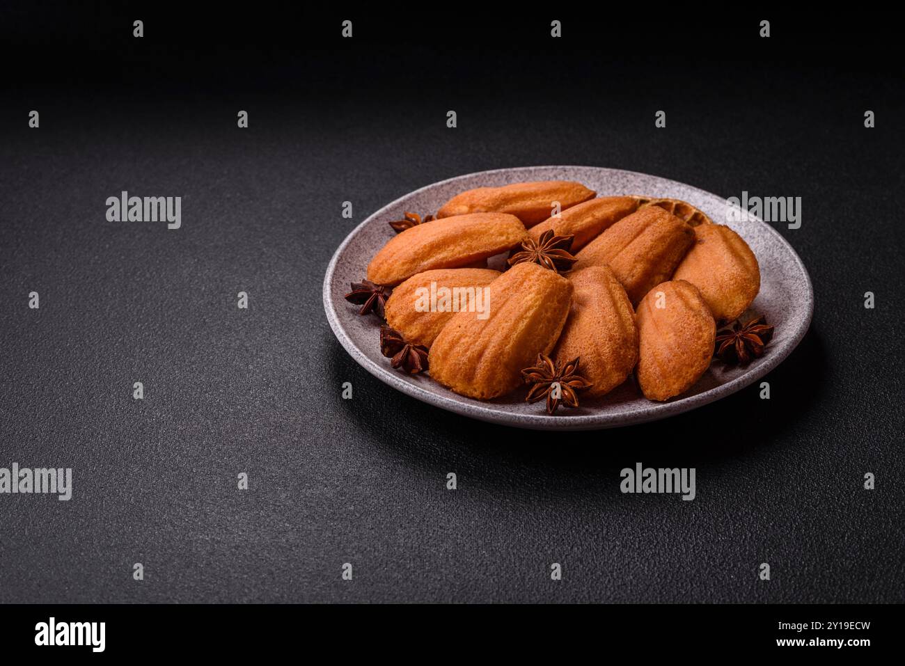 Traditional French madeleine biscuits with nutty flavor on a dark ...