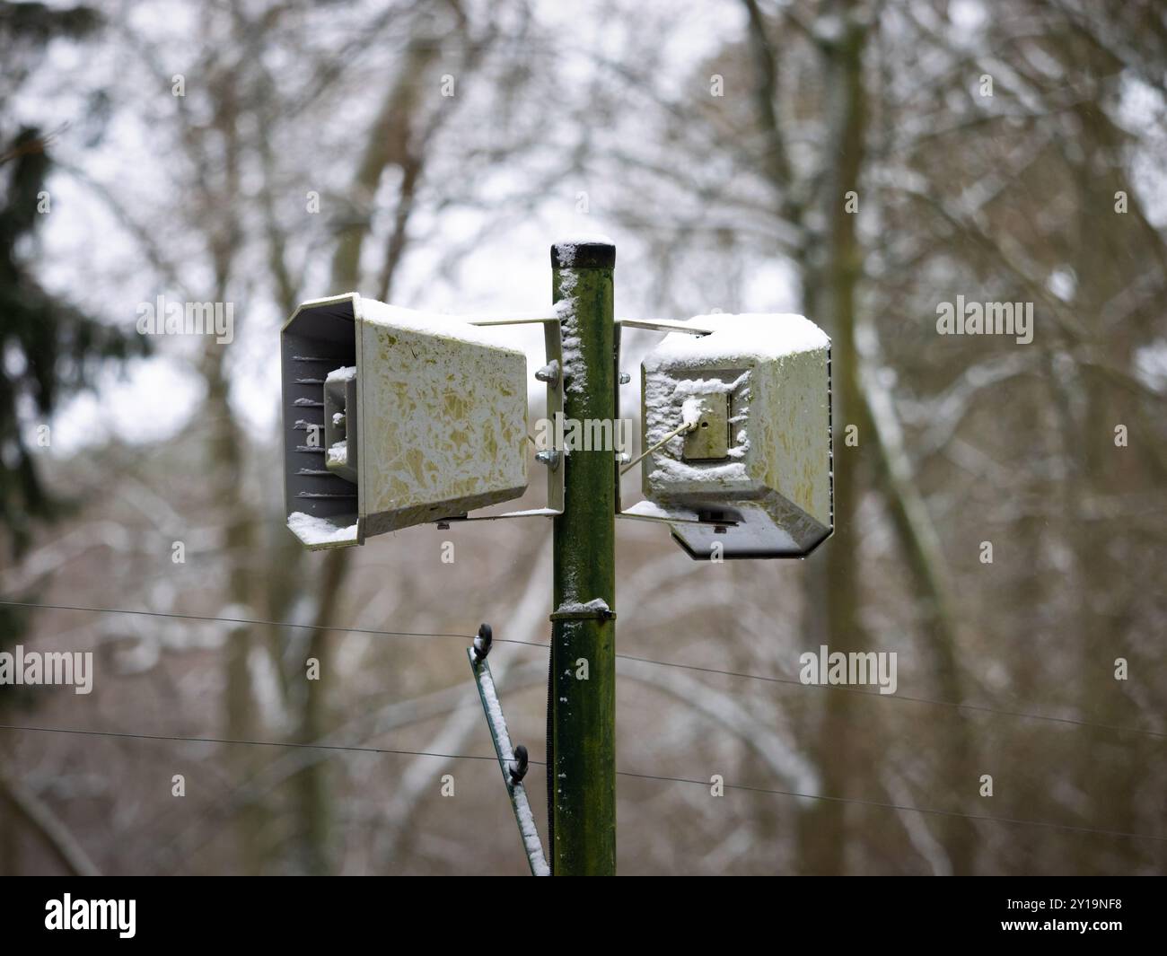 Outdoor horn speaker covered in snow. Warning alert above an electric ...