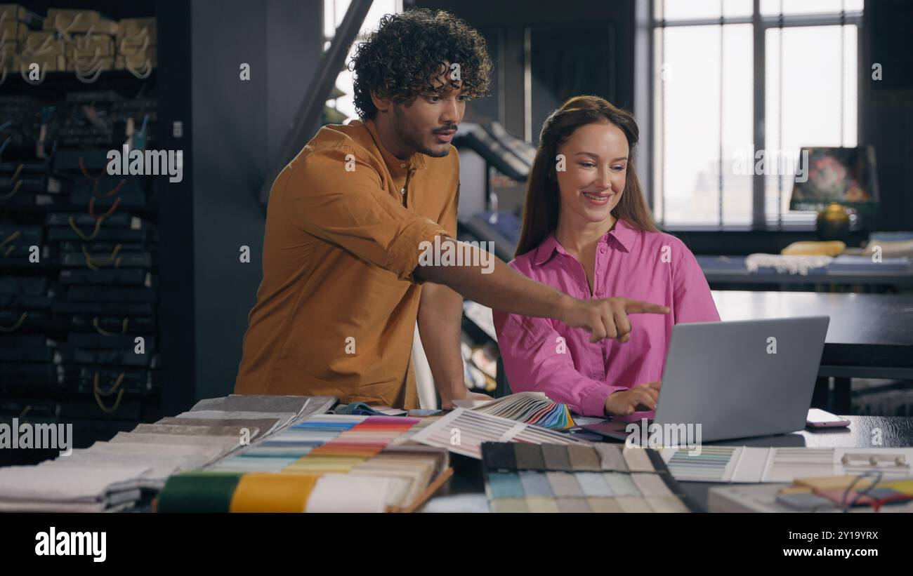 Multiracial business coworkers male female fashion designers work laptop discuss design project ...