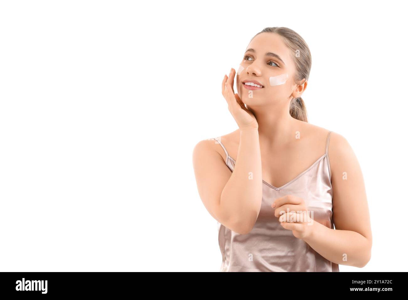 Beautiful young woman applying cosmetic cream on her face against white background Stock Photo ...
