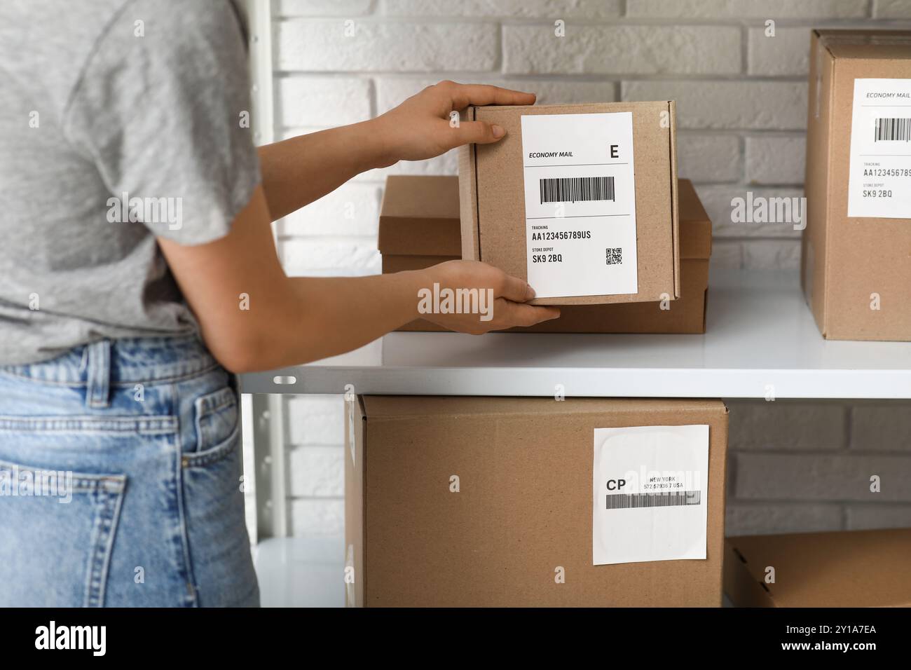 Woman taking parcel from shelf at postal warehouse, closeup Stock Photo ...