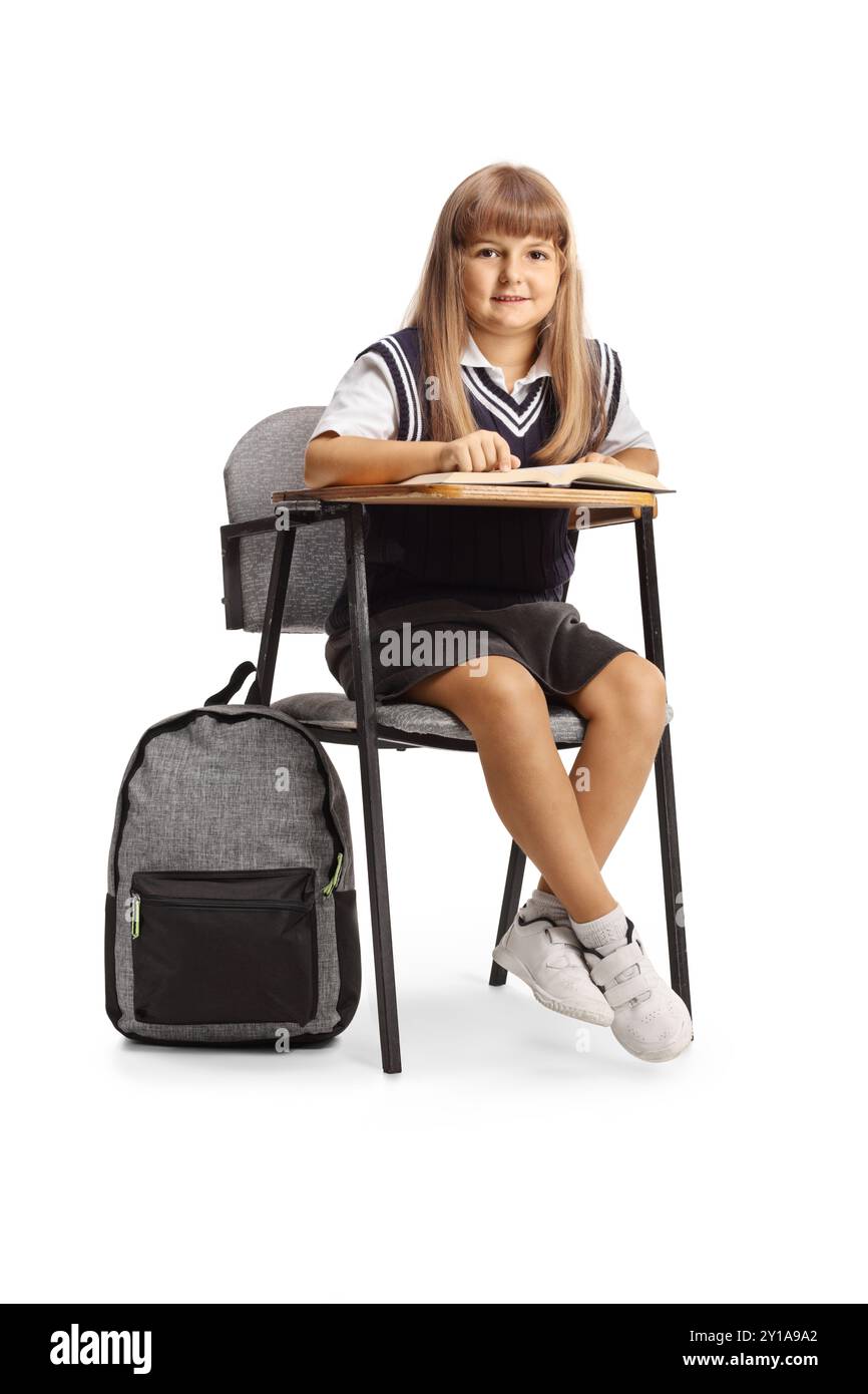 Smiling schoolgirl sitting in a chair and reading isolated on white background Stock Photo - Alamy