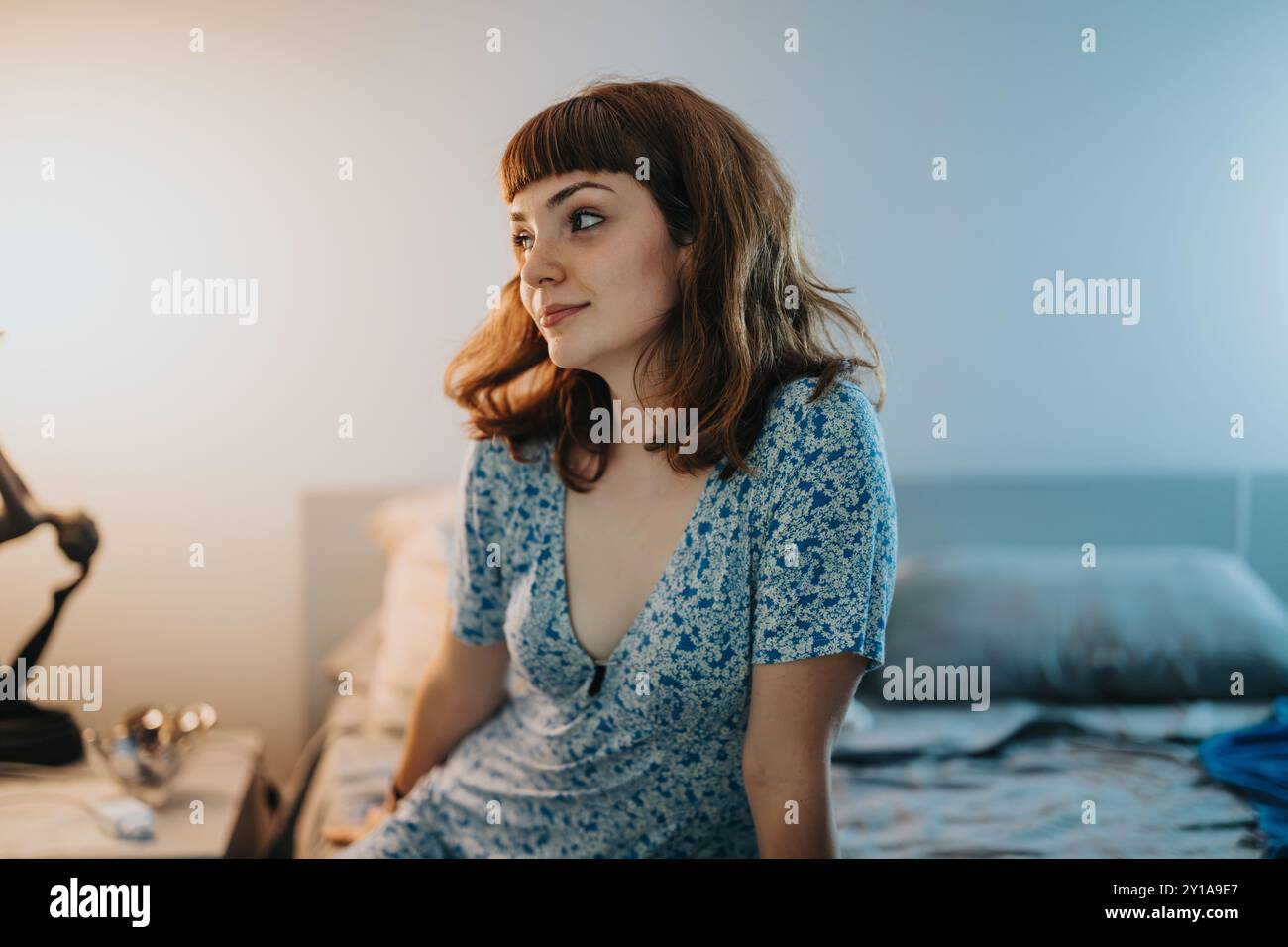 Woman in blue dress preparing for a night out at home Stock Photo - Alamy