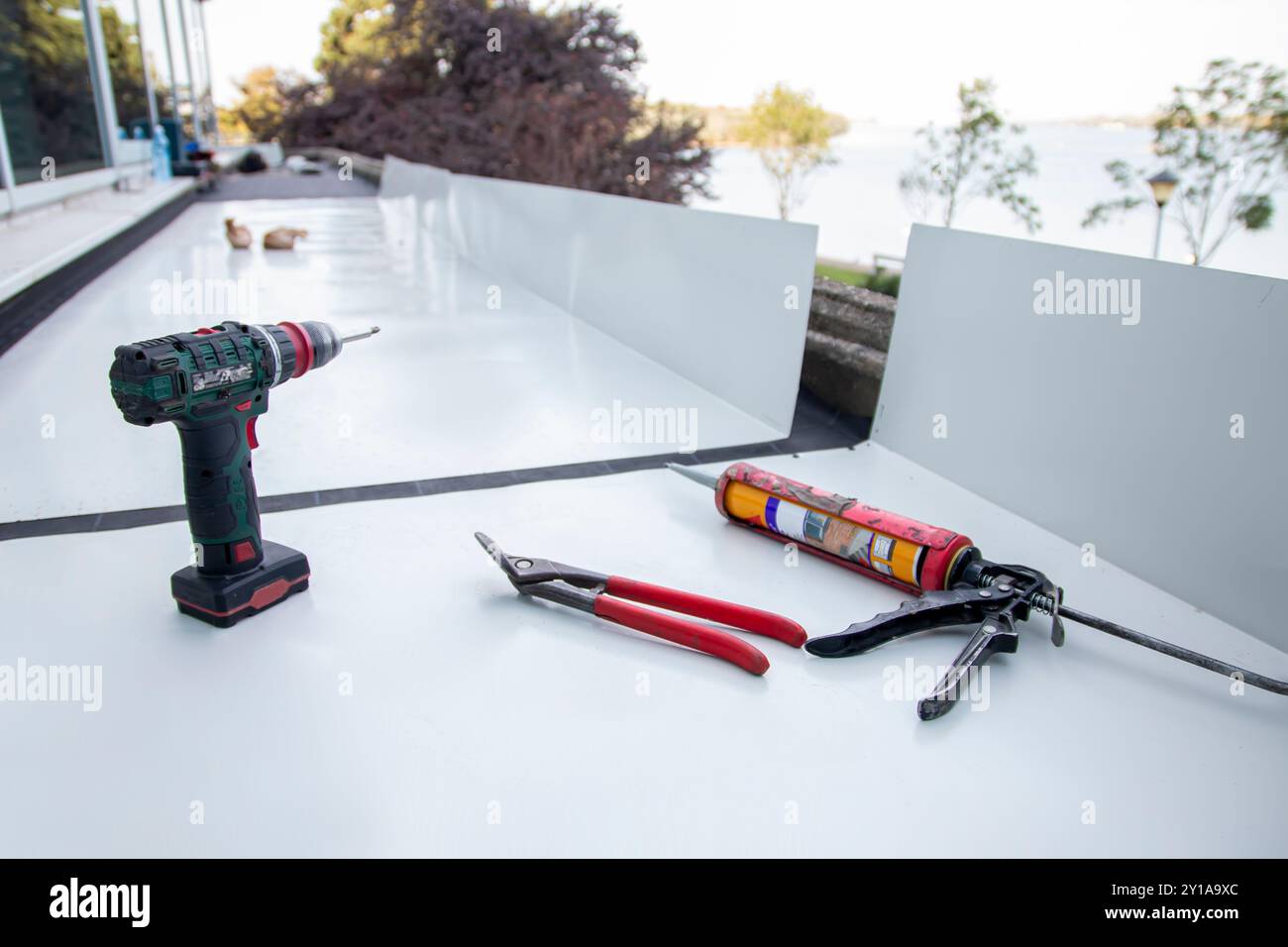 Tinsmith worker using cordless drill screws, scissors to cut the metal ...