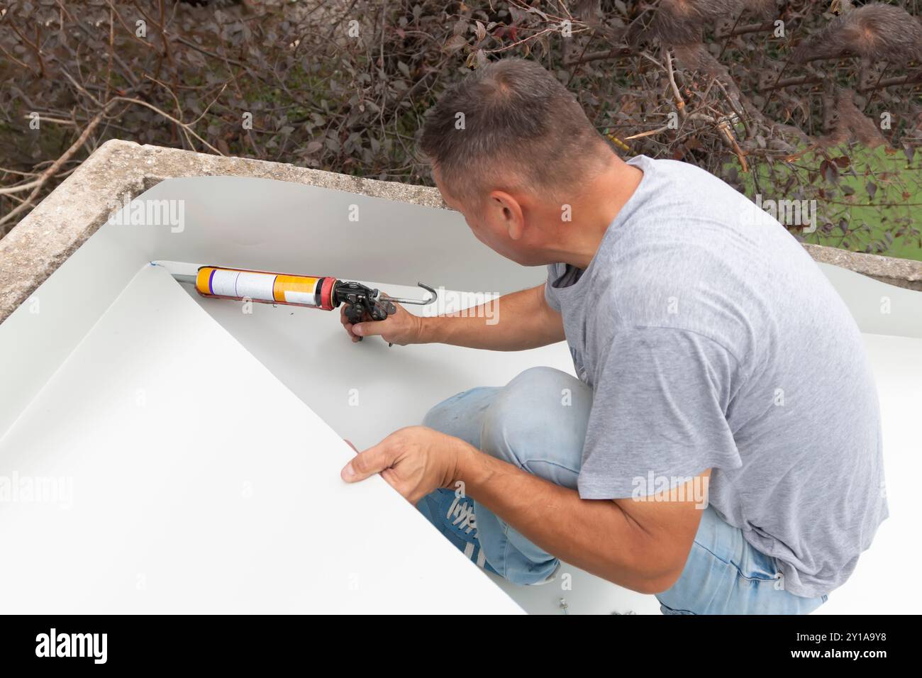 Man using sealant gun at roofing construction. Construction worker with ...
