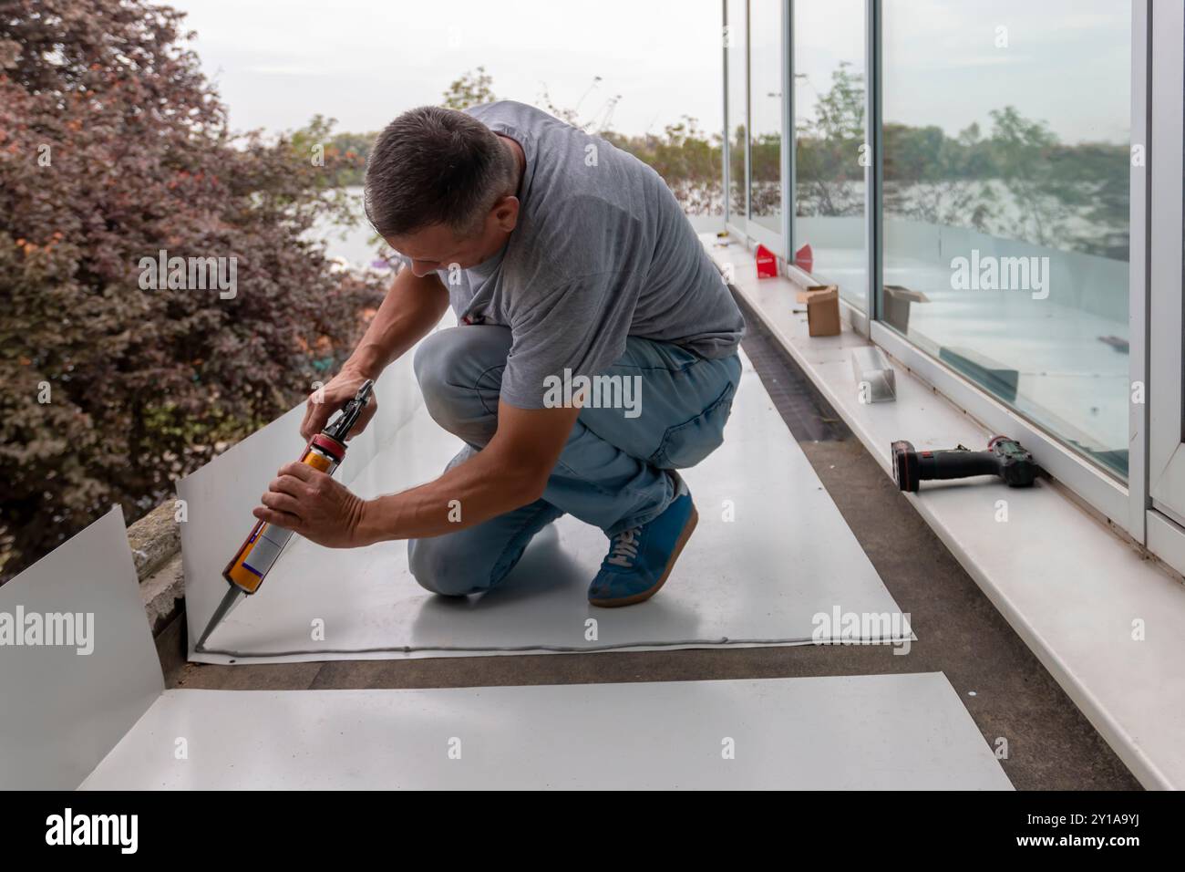 Man using sealant gun at roofing construction. Construction worker with ...