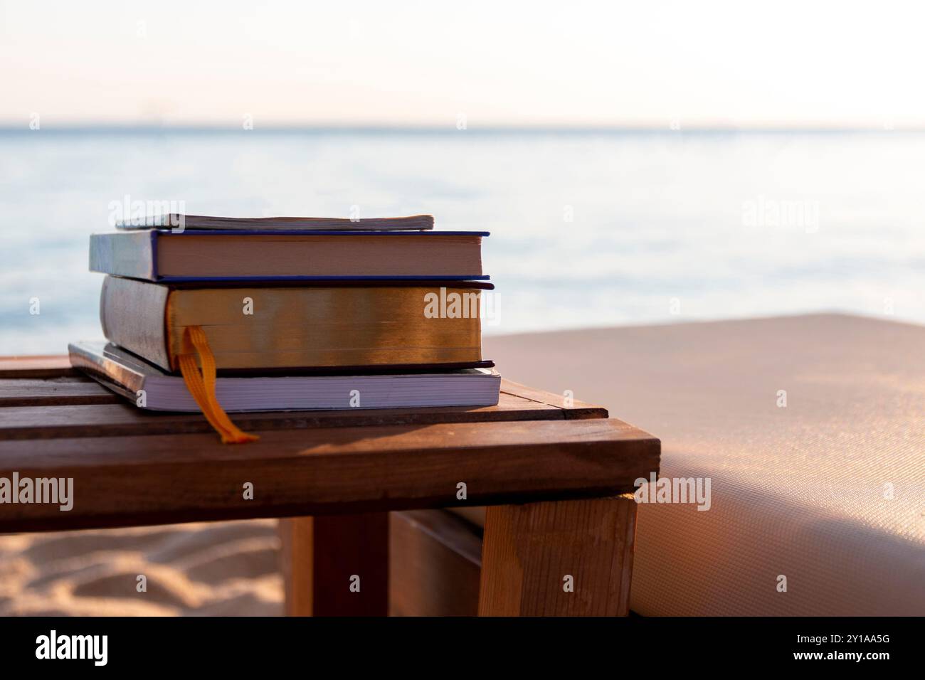 Books on the beach beside sea at sunset. School concept Stock Photo - Alamy