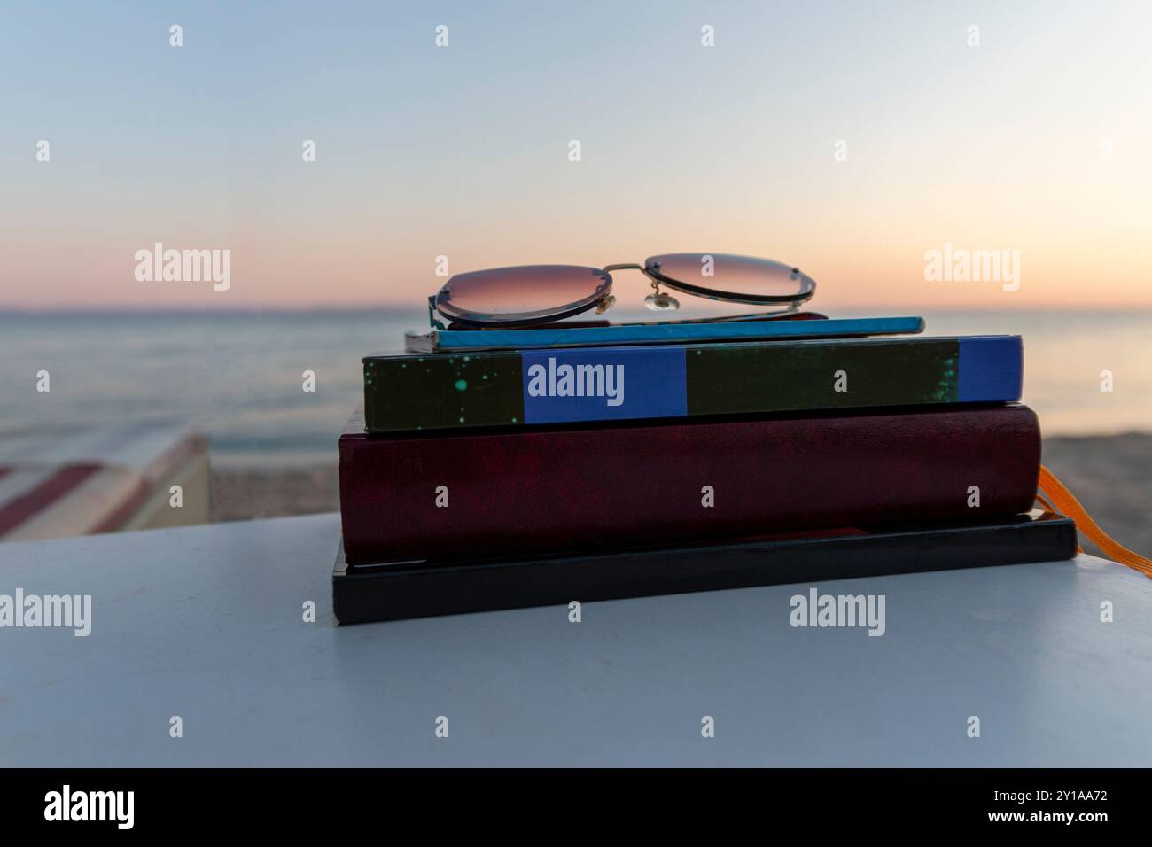 Books on the beach beside sea at sunset. School concept Stock Photo - Alamy