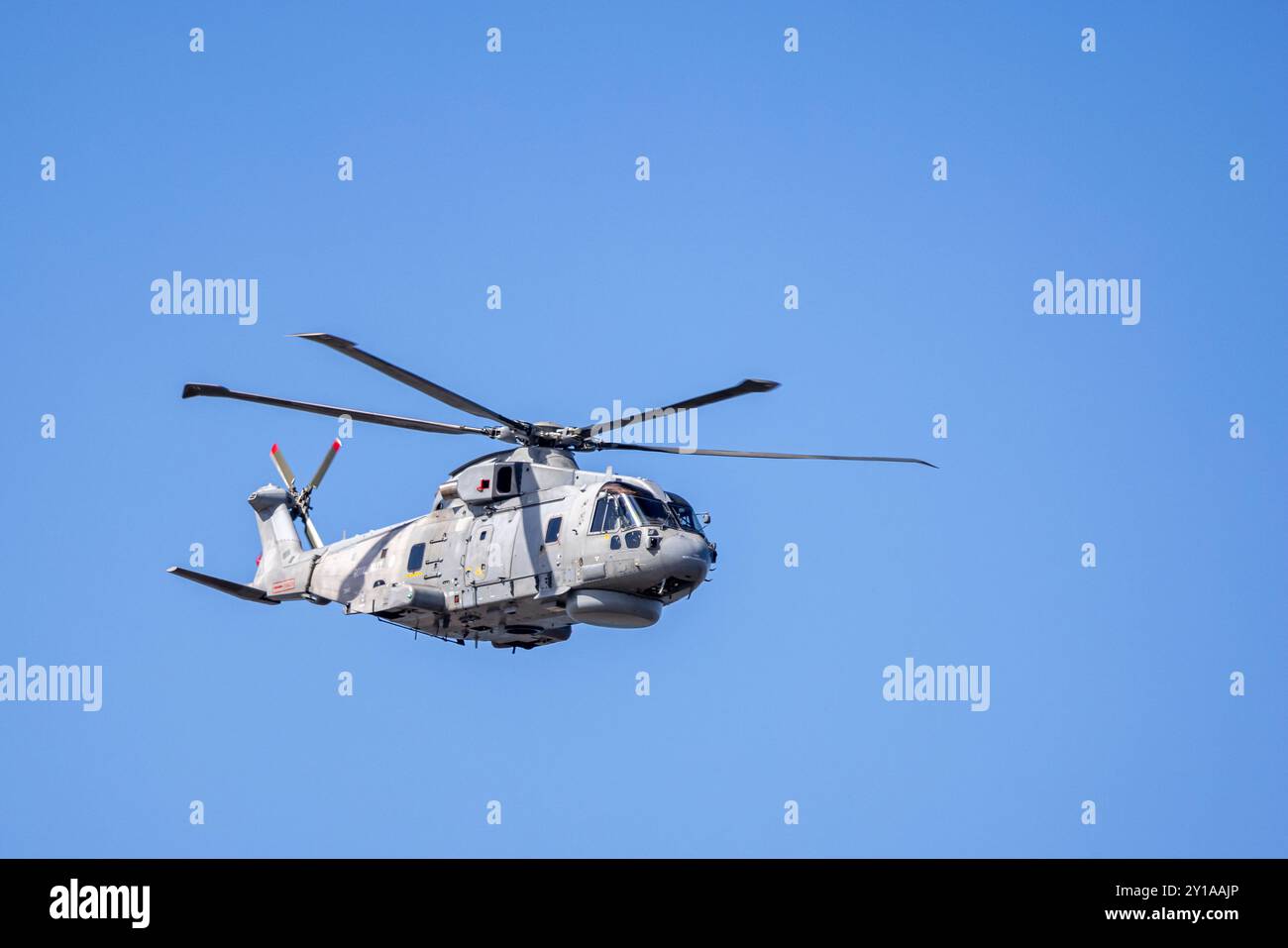 Royal Navy Merlin helicopter flying over the sea at Westward Ho beach ...
