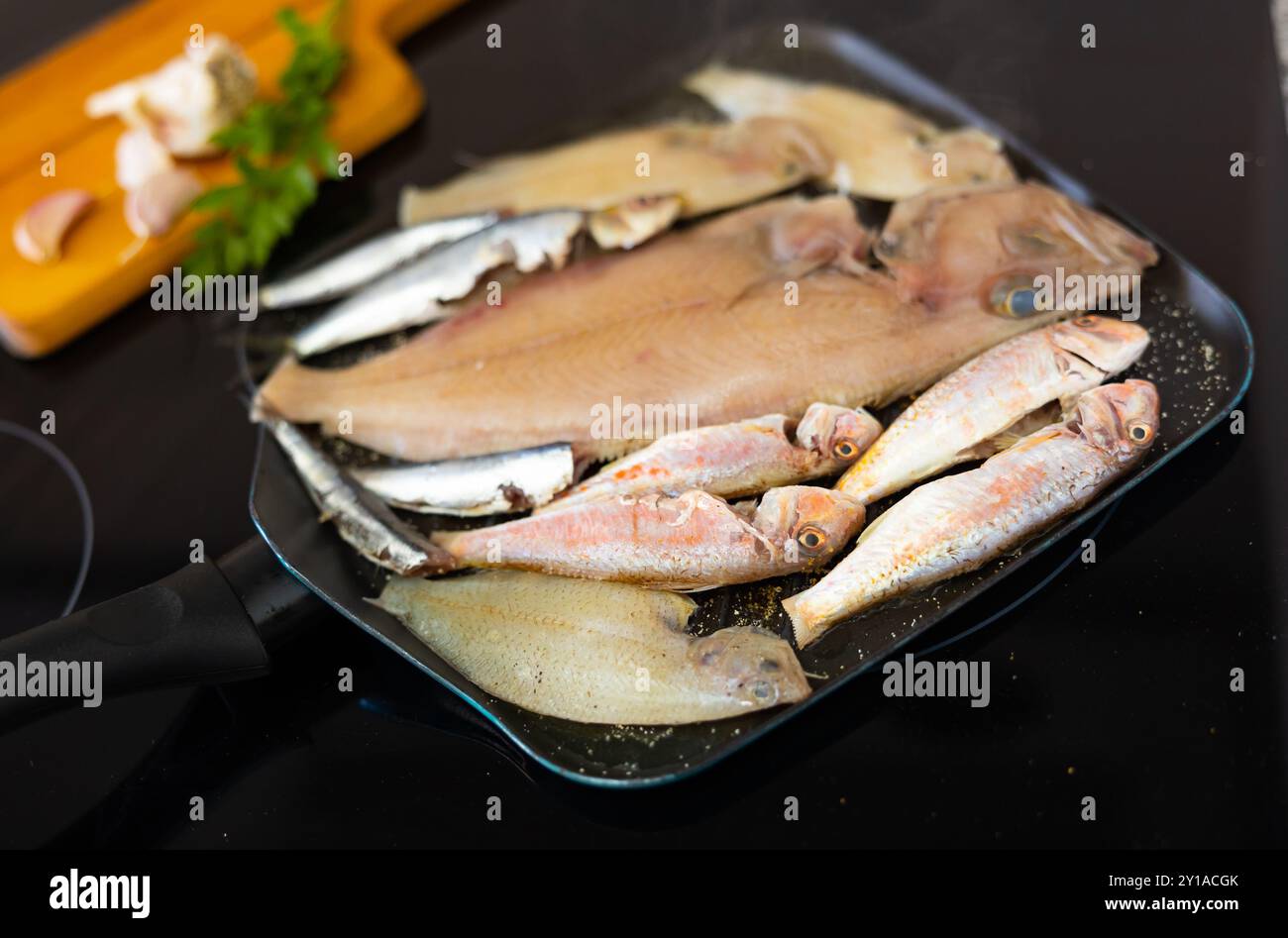 Carcasses of raw Atlantic fish of various species are laid out in ...