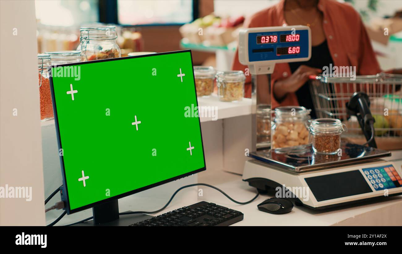 Merchant selling goods next to pc with greenscreen at checkout, locally ...