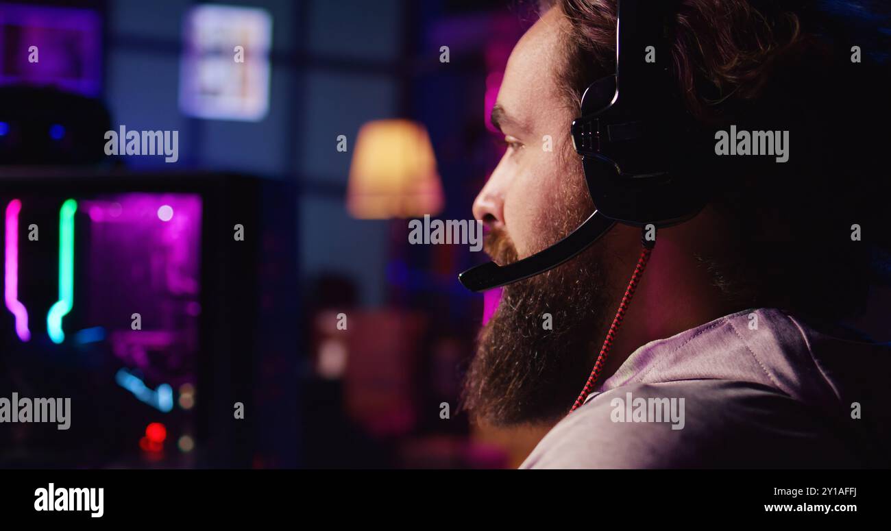 Zoom in on man enjoying coop FPS videogame, battling flying robots with ...