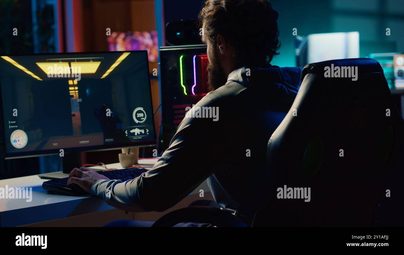 Man sitting on gaming chair, playing first person shooter videogame ...