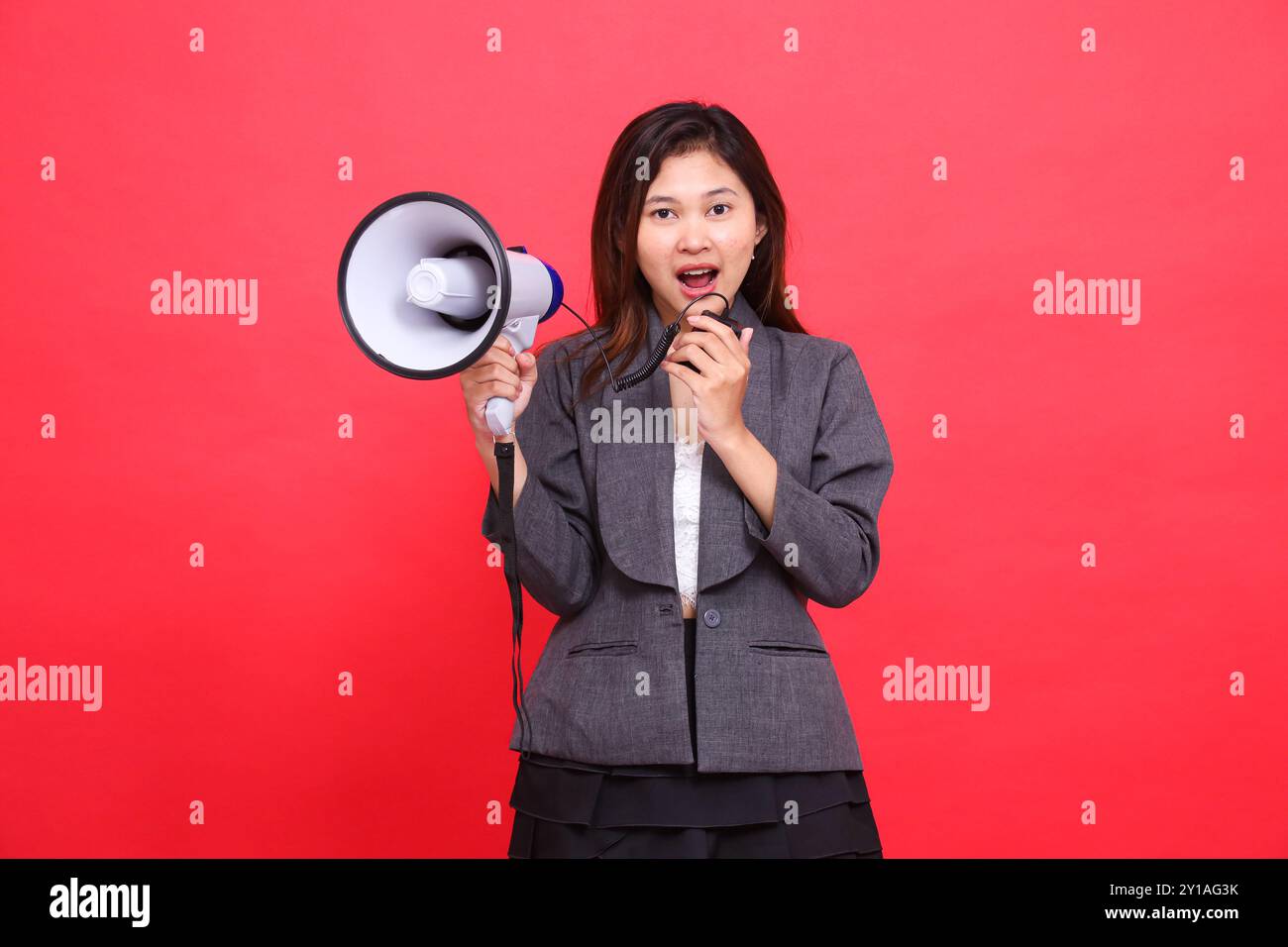 Asian female leader's expression, shouting casually, using a megaphone ...
