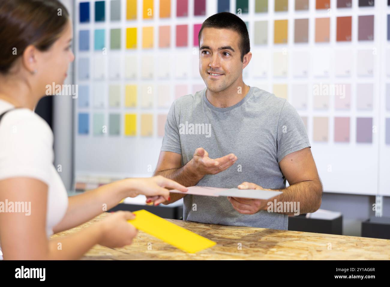 Polite salesman of painting supply store consulting female client Stock ...