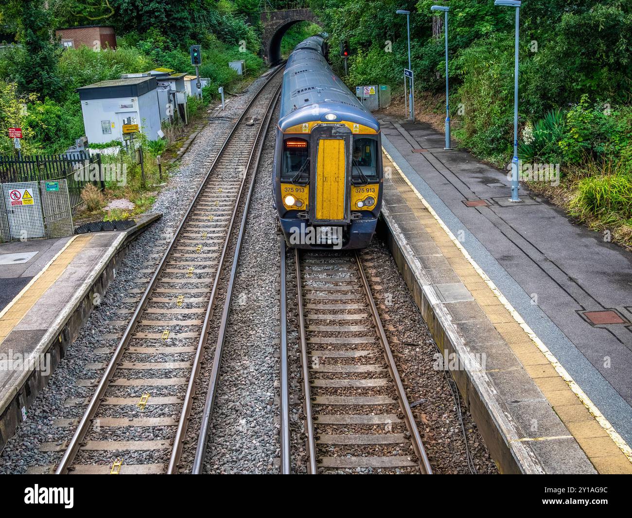 A train approaches Sandling railway station, as seen from an aerial ...