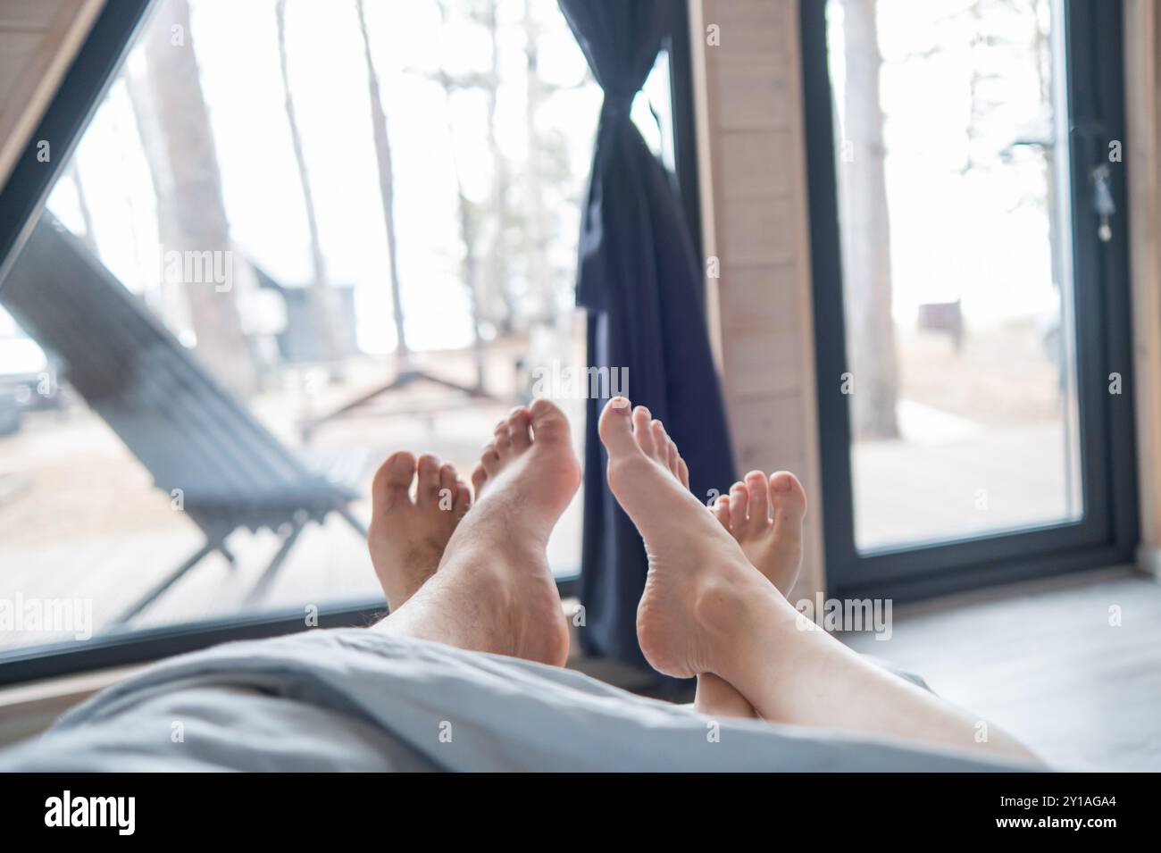 The feet of a married couple sticking out from under the blanket in a ...