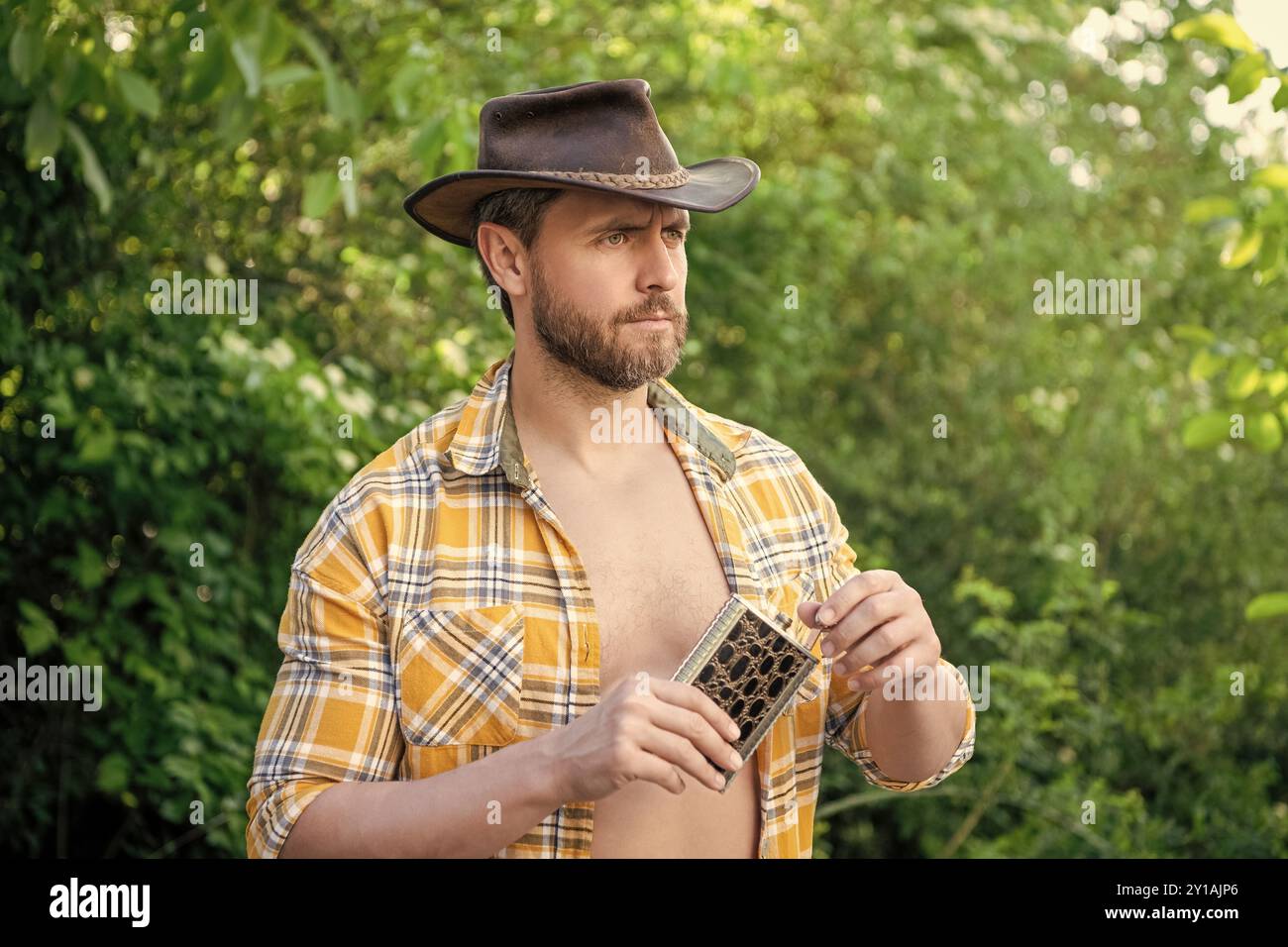 masculine cowboy holding flask wear hat. photo of masculine cowboy with ...