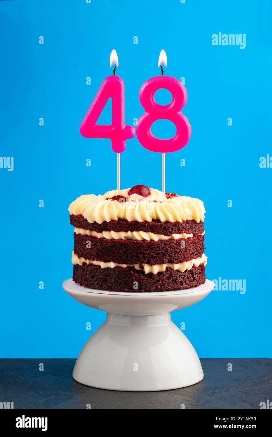 Red velvet birthday cake with number 48 candle Stock Photo - Alamy