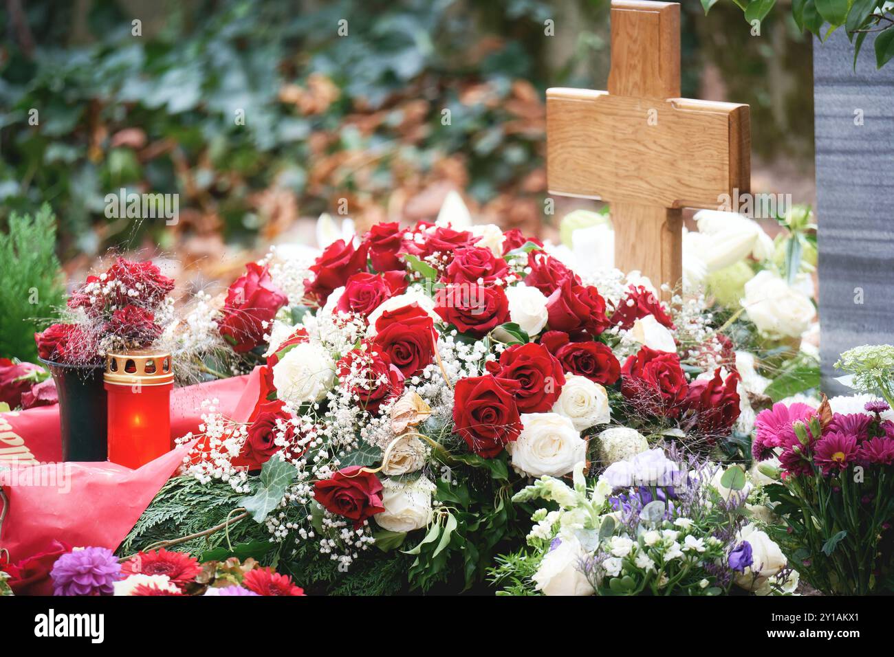 bouquet of white and red roses with red ribbon and grave light on a ...