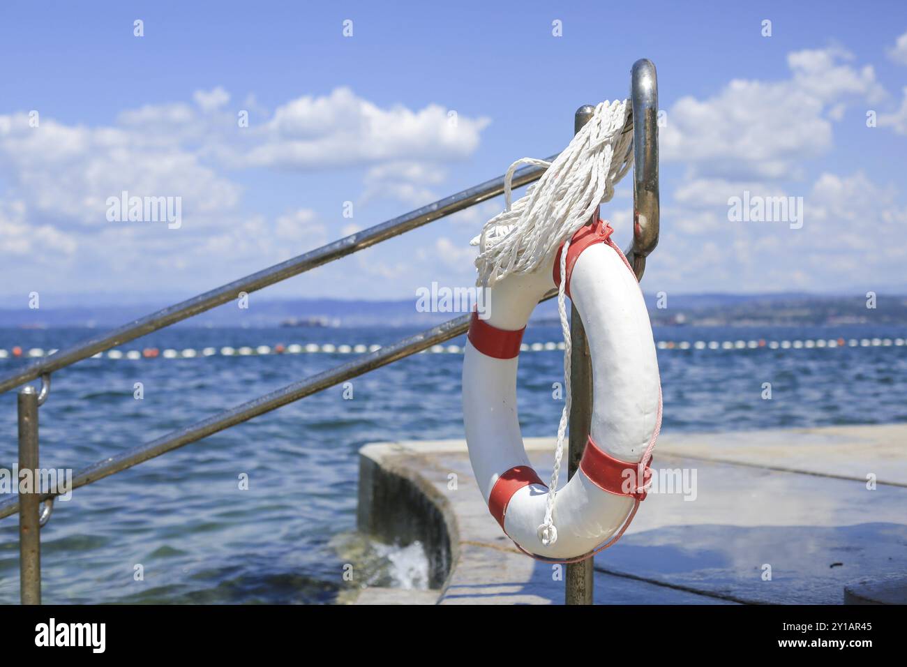 Emergency lifebuoy hanging on fence near sea at beach Stock Photo - Alamy