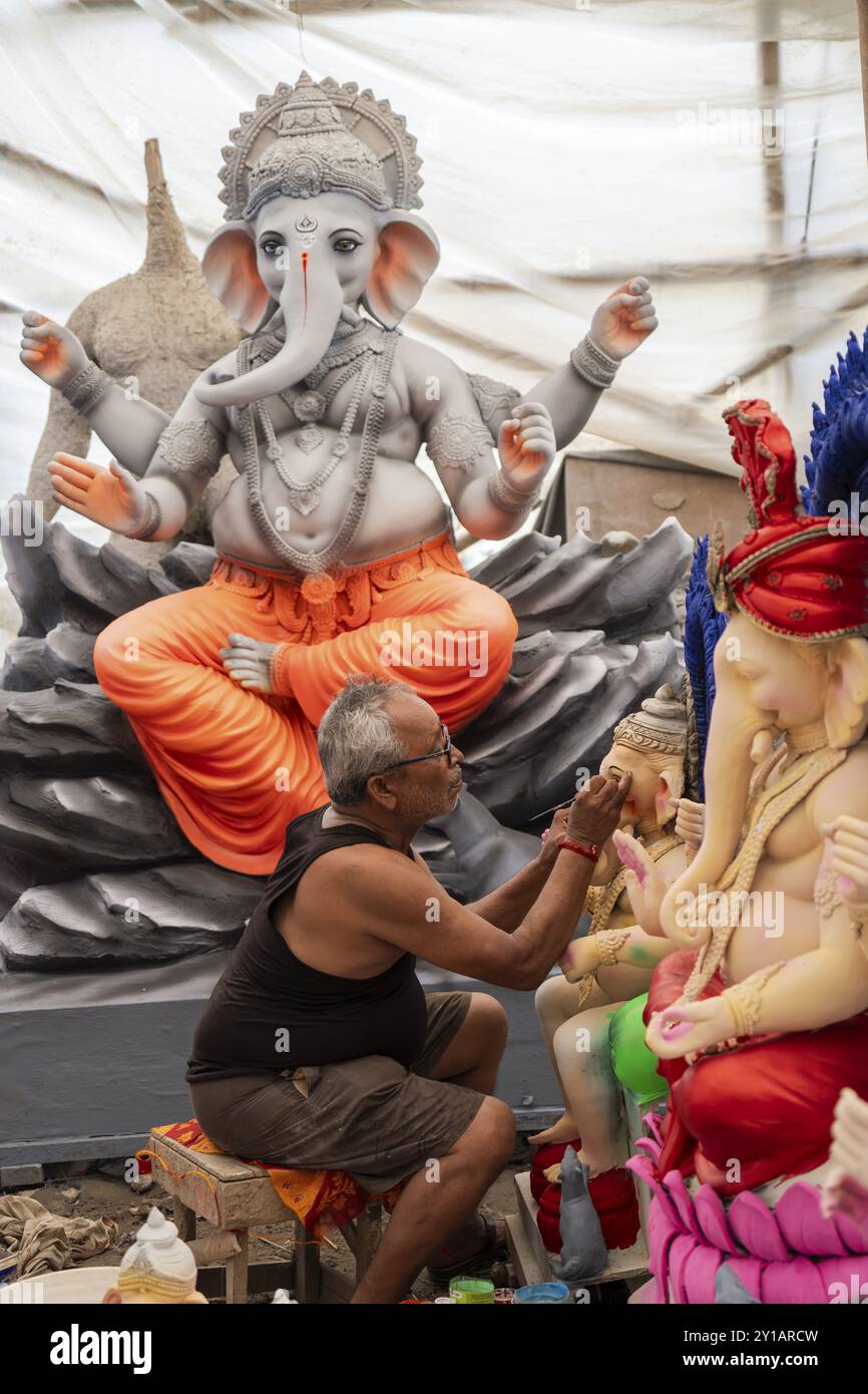 An artisan gives final touches to an idol of the elephant-headed Hindu ...