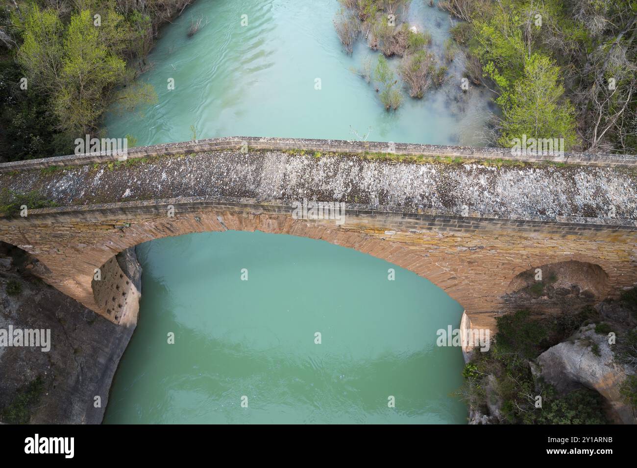 Historic brick bridge over turquoise river surrounded by green nature ...
