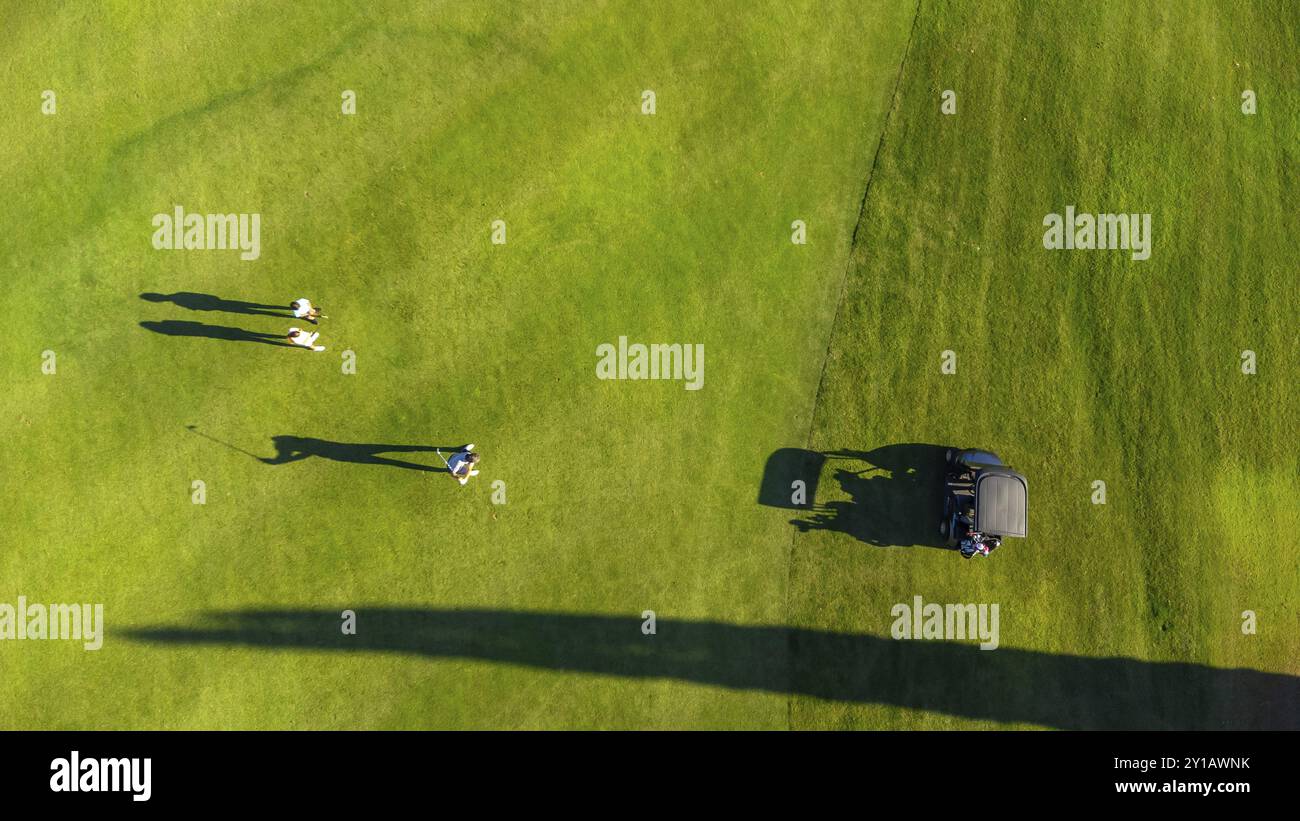 Aerial top view of three people on a green luxury gold course Stock ...