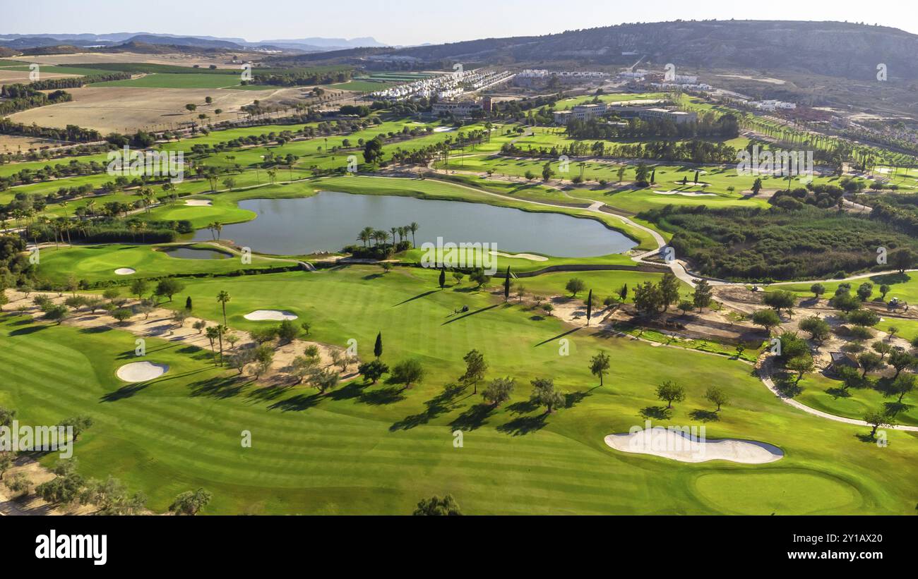 Wide aerial view of a luxury golf course with green grass and a lake ...