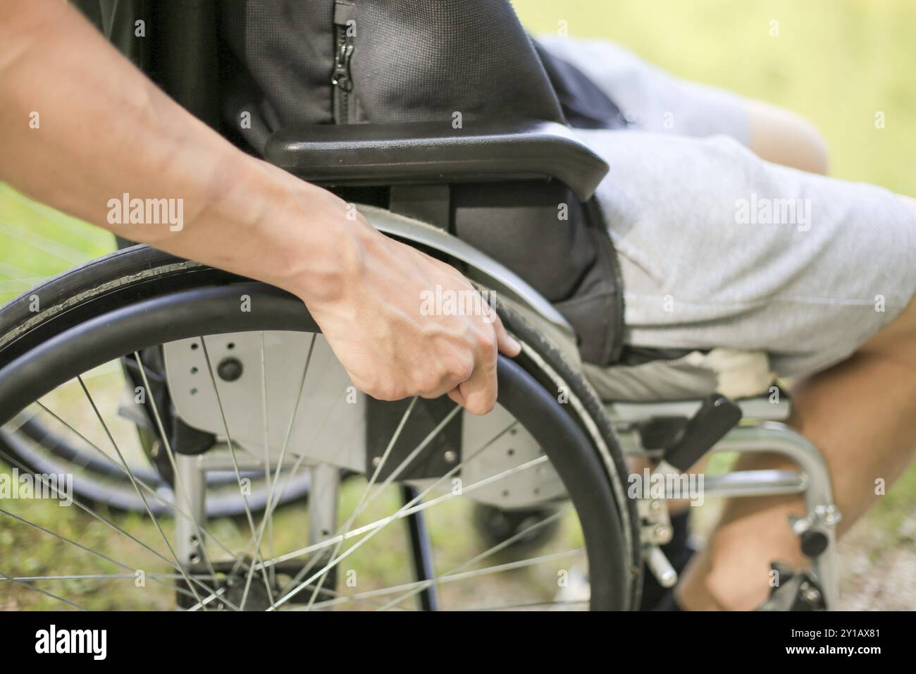 Young disabled or handicapped man sitting on a wheelchair in nature ...