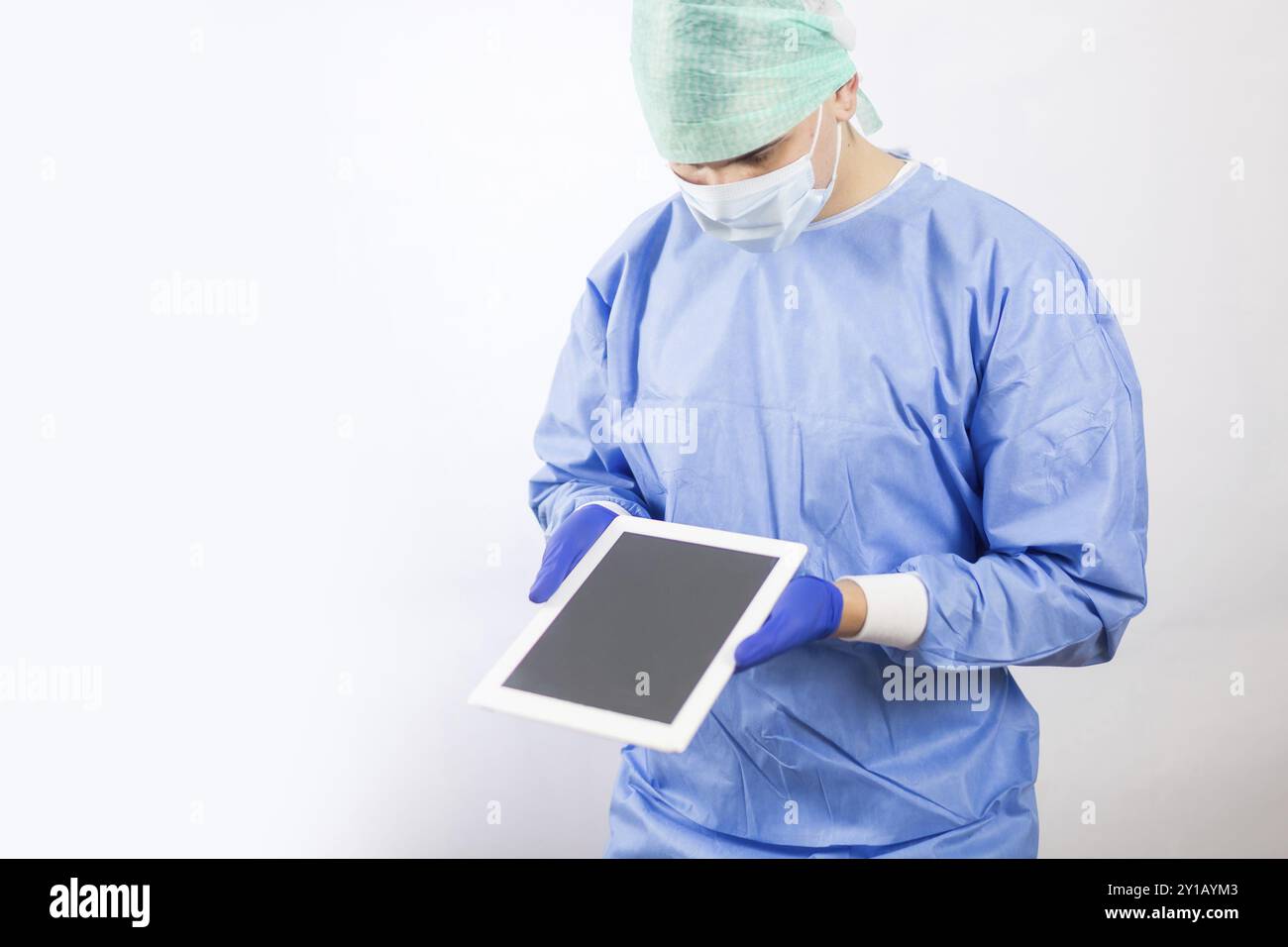 Surgeon doctor in sterile gloves preparing for operation using tablet ...