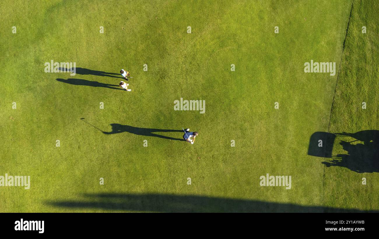 Aerial top view of three people in a green luxury gold course Stock ...